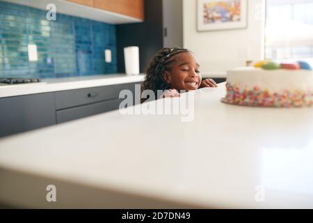Girl Hiding Behind Kitchen Counter Takes Sneaky Look At Birthday Cake ...