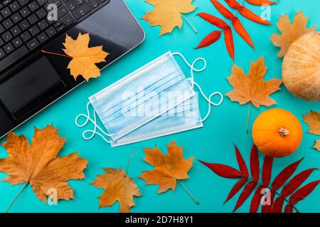 Laptop computer with masks in autumn. Yellow autumn leaves. Top view ...