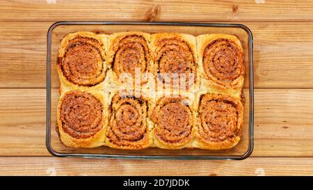 Homemade cinnamon rolls from yeast dough and cup of tea on wooden table ...