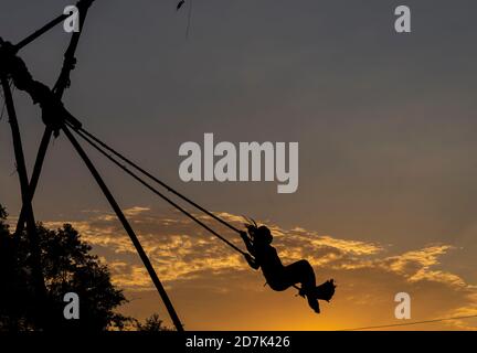 Nepalese girl playing on a traditional bamboo swing called linge ping ...