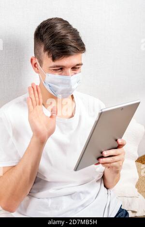Young man with tablet computer video chatting on online date at home ...