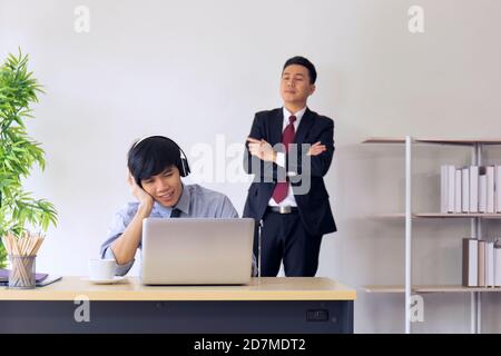 portrait of male supervisor stood behind apprentice using circular saw ...