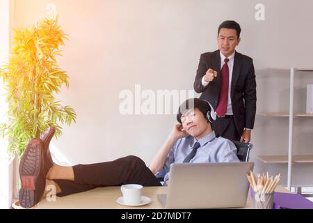 portrait of male supervisor stood behind apprentice using circular saw ...