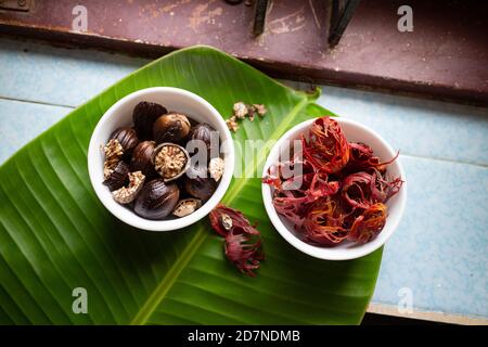 Whole Nutmeg seeds, mace or aril in stone mortar on light blue ...