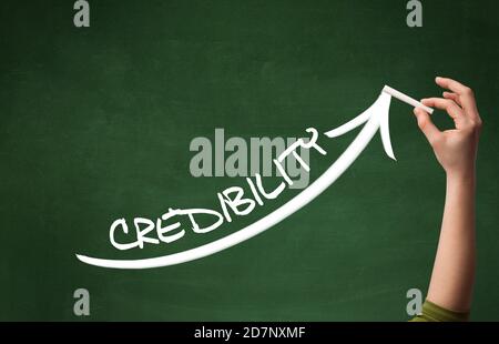 Hand drawing CREDIBILITY inscription with white chalk on blackboard ...