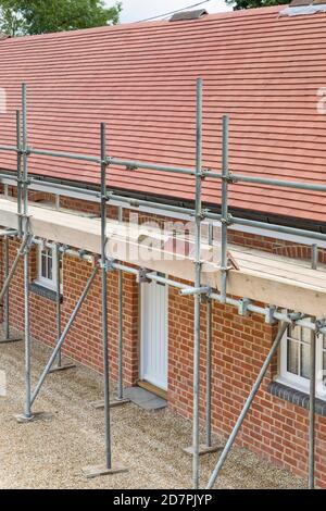Scaffolding outside a UK house extension, barn conversion to single ...