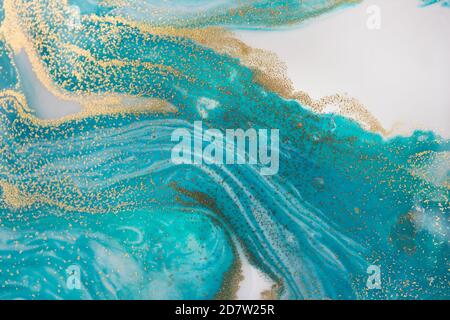 Gold and light blue mixed inks spilled background. Turquoise texture ...