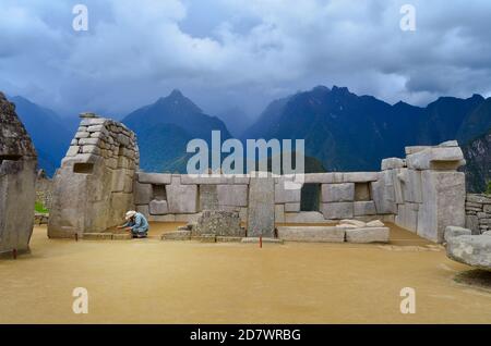 Machu Picchu interior, a man working on reconstruction Stock Photo - Alamy