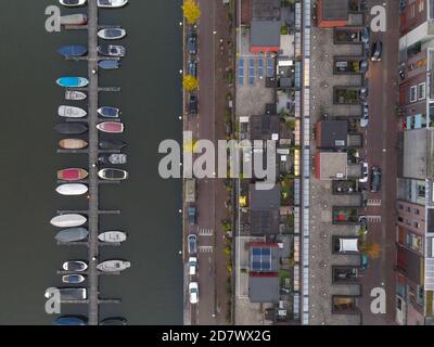 A drone shot of residential buildings and houses in a town near a field ...