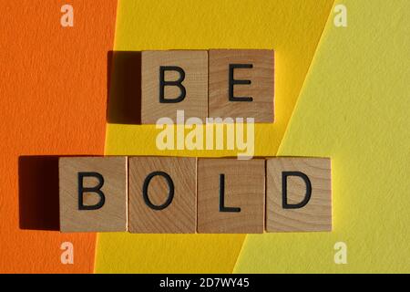 Be Bold, words in wooden alphabet letters isolated on bright orange ...