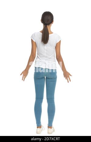 back view of surprised beautiful brunette young woman with hands up ...