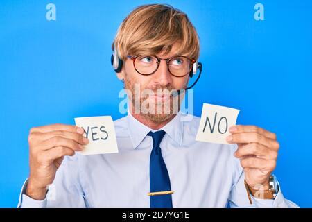 Young blond man wearing operator headset working at online shop ...