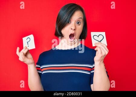 Emotional woman with question mark sticker on forehead against black ...