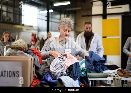 Volunteers giving clothes to homeless people outdoors Stock Photo - Alamy