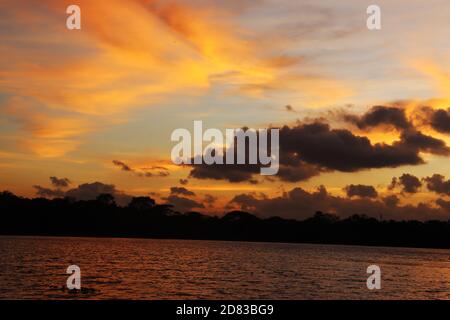 A scenic sunset view with the sun hiding behind the fluffy clouds over ...