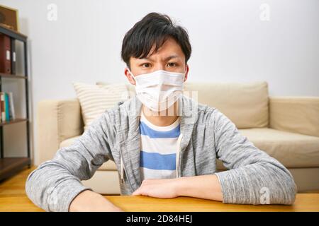 Sick Japanese man working from home Stock Photo - Alamy