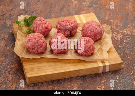 Raw meatball over wooden background ready for cooking Stock Photo - Alamy