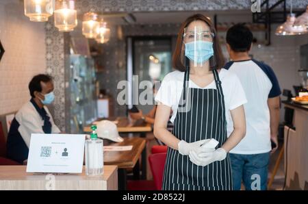 Employee with face mask holding customers credit card to pay for ...