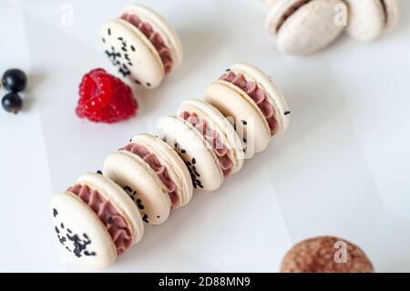 Macarons and berries on white table Stock Photo - Alamy