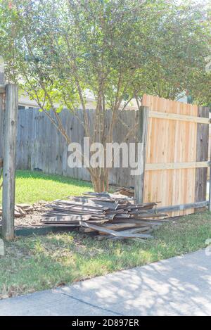 Concrete back alley with old fence near new lumber boards pickets at ...