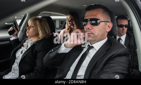 Famous female celebrity with bodyguards surrounded. VIP security agents ...