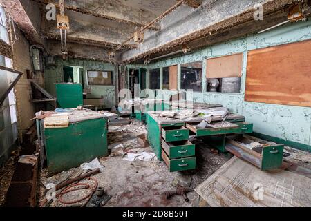 Creepy abandoned office room inside with old wooden table and windows ...
