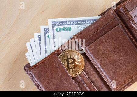 Gold bitcoin with dollars in brown leather wallet. Virtual ...