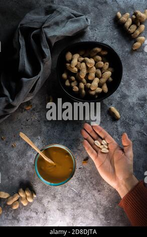 Aerial view photograph of homemade peanut butter in a blue bowl and one ...
