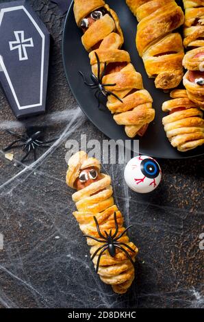 Scary sausage mummies in dough with funny eyes on table. Funny ...