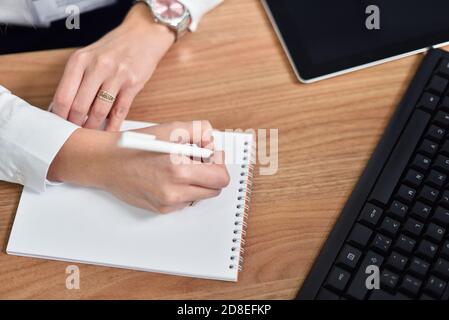 Businesswoman makes a note in notebook Stock Photo - Alamy