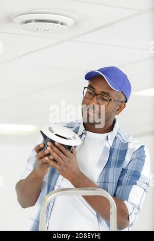 Man installing smoke detector Stock Photo - Alamy