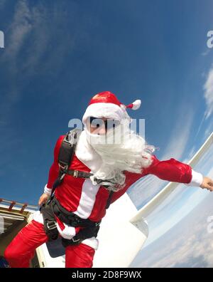 This skydiver in a Santa Claus costume is falling free in a sit ...