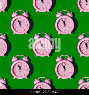 Seamless pattern with pink clocks on a dark blue background, repeating ...