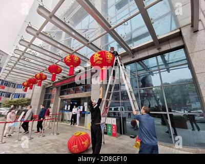Red lanterns and national flags are seen flying along the Yihe street prior to the National Day ...