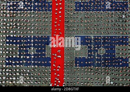 An aerial view of students arraying on the playground, attending a ...