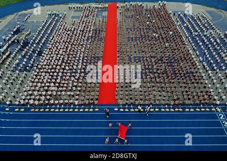 An aerial view of students arraying on the playground, attending a ...