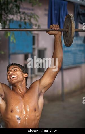 Delhi, India, May 2012. Kushti fighters preparing the akhara arena for ...
