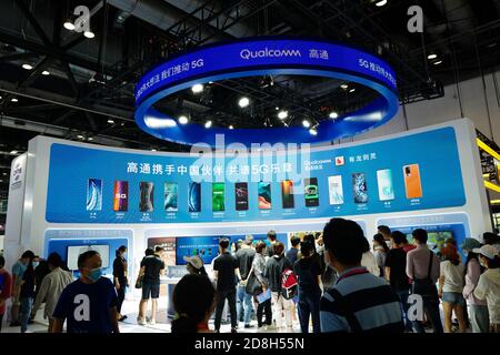 In this unlocated photo, visitors gather at the booth of Qualcomm, an ...