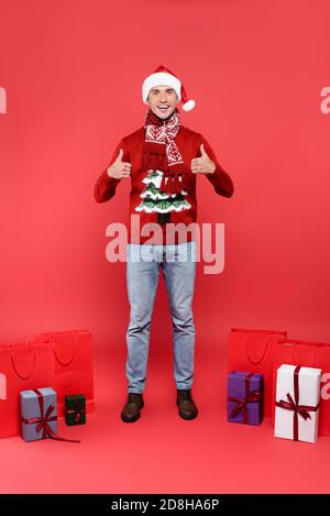 Gift shopping. Happy santa like holiday shopping. Bearded man point at ...