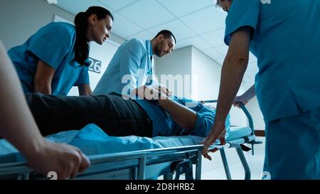 Doctors, nurses and paramedics run and push stretcher with seriously ...