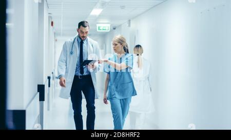 Surgeon and Female Doctor Walk Through Hospital Hallway in a Hurry ...