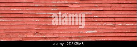 Red barn with faded paint and old sign covered in vines during late ...