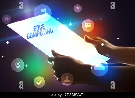 Holding futuristic tablet with EDGE COMPUTING inscription, new ...