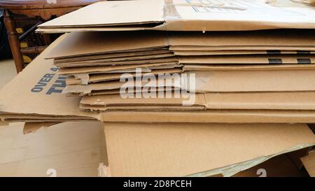 Flattened cardboard moving boxes stacked and piled up ready for ...