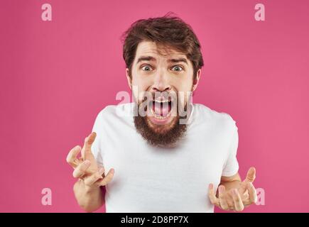 An angry man with a bushy beard bared his teeth against a pink ...