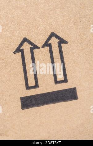 Black upward pointing arrows logo on the side of a cardboard packaging ...