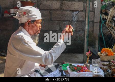 Close up of a Balinese pedanda during prayer. side view of a hindu ...