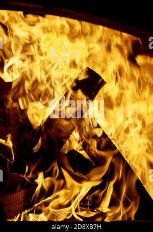 Close up of burning firewood with bright orange flames and smoke ...