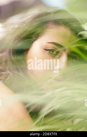 Scared woman peeking through the grass Stock Photo - Alamy