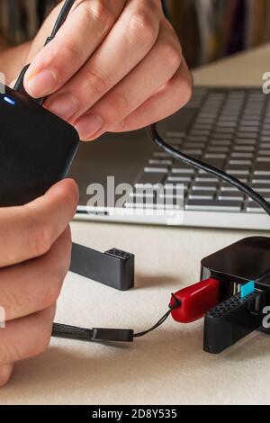 Hand connecting usb hard drive to laptop, modern personal computer ...